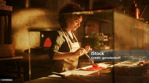 레스토랑에서 전문 여성 요리사가 피자를 준비하고 재료 특수 소스 치즈 전통적인 가족 레시피를 추가합니다 정통 햇볕이 잘 드는 이탈리아 피자 가게 유기농 음식 요리 낮에 대한