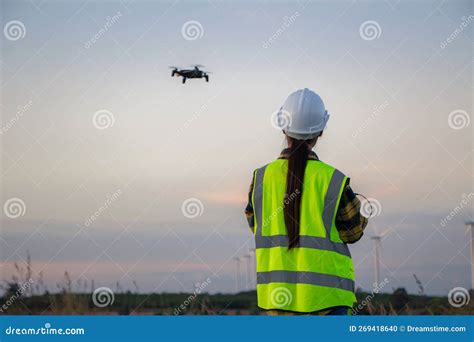 Asian Female Engineer Using Drone For Inspection Wind Turbine Farm In Evening Stock Photo
