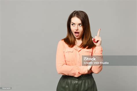 파스텔 캐주얼 옷 옆에 보이는 젊은 여자를 깜짝 놀라게 회색 벽 배경에 고립 된 좋은 새로운 아이디어와 인덱스 손가락을 들고 사람들은 진심으로 감정 라이프 스타일 개념입니다