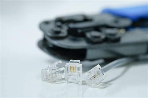 Rj11은 커넥터 및 압착 케이블 흰색 테이블에 전화 및 네트워크 시스템에 대 한 연결 합니다 닫기 최대 선택적 네트워크 도구 흰색 배경에 초점 0명에 대한 스톡 사진 및