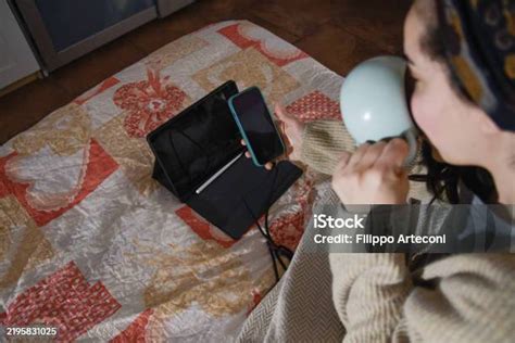 침대에 스마트 폰과 태블릿을 가진 여자가 컵에서 물을 마시고 있습니다 25 29세에 대한 스톡 사진 및 기타 이미지 25 29세 Brand Name Smart