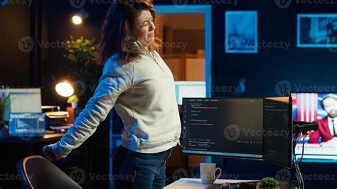 Programmer Doing Software Quality Assurance Stretching Arms Behind Back After Reading Source