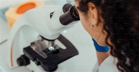 과학적 조사 연구를 하는 동안 현미경을 들여다보고 있는 검은 머리 여자의 상위 뷰 사진 Unsplash의 보호 장갑 이미지