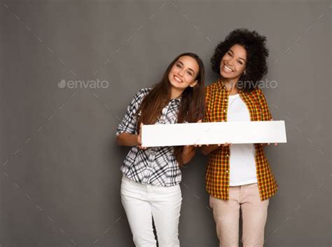 Two Girlfriends Holding Blank White Banner Attractive Background