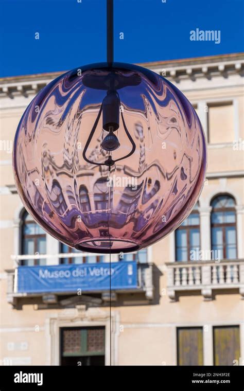 Close Up Of Pink Murano Glass Light With Reflections Hanging Opposite