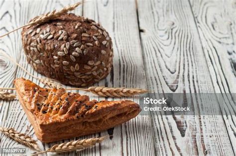 삼각형 모양의 빵 두 덩어리와 밀가루 스파이크릿 근처의 해바라기 씨앗이 오래된 풍화 된 흰색 나무 테이블에 놓여 있습니다 갈색에 대한 스톡 사진 및 기타 이미지 Istock