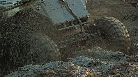 진흙탕에 빠진 Suv의 앞부분을 클로즈업한 모습 바퀴가 돌아가고 물보라와 진흙이 그 아래에서 날아다닙니다 익스트림 머드 레이싱 0명에 대한 스톡 사진 및 기타 이미지