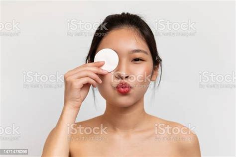 화장솜으로 화장을 지우고 공기 키스를 하는 완벽한 피부를 가진 예쁜 한국 여자 흰색 배경에 포즈 18 19세에 대한 스톡 사진 및 기타 이미지 Istock