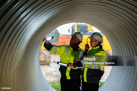 남녀 엔지니어가 대형 강관 내부를 검사합니다 작업자들은 산업 플랜트에서 석유 천연 가스 및 연료를 운송하기 위한 파이프라인을 건설합니다 2명에 대한 스톡 사진 및 기타