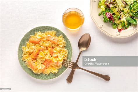 파스타와 와인 이탈리아 저녁 식사 훈제 연어와 크림 소스가 있는 Farfalle은 정상에서 와인 한 잔으로 촬영 하 고 메 클 룬은 샐러드를 남기고 복사 공간을 고급 요리에