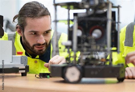 Robotic Engineer Monitoring Robot Arm Connection For Maintenance In