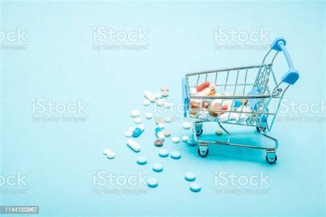 알 약 및 파란색 배경에 쇼핑 트롤리 의료 비용 약국 건강 보험 및 제약 회사 비즈니스 개념에 대 한 창의적인 아이디어 복사 공간 0명에 대한 스톡 사진 및 기타 이미지