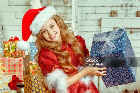 행복 Hollidays입니다 근접 촬영 귀여운 금발 여자의 몸 길이 절반 아이 산타 레드햇 지주 선물 크리스마스 이브 격리 상자 전나무 트리 배경 산타 도우미에 집