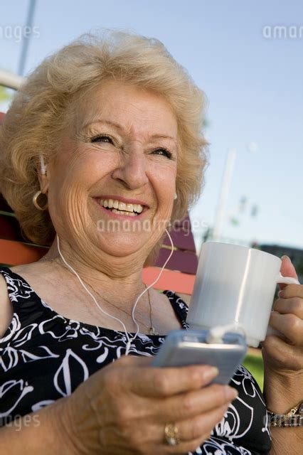 Senior Woman Outdoors Listening To Portable Music Playerの写真素材 Senior Woman Outdoors Listening To Portable Music Playerの写真素材