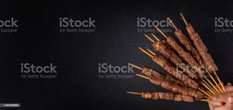 케밥 또는 아로스티치니 또는 촨이라고도 하는 양고기 꼬치는 숯불 위에 나무 꼬치에 구운 작은 고기 조각입니다 검정 배경 배너 크기 복사 공간 꼬챙이에 대한 스톡 사진 및