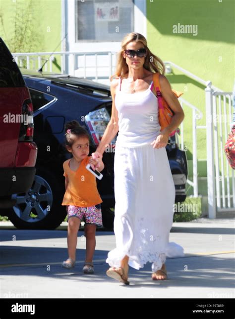 Denise Richards In A White See Through Cotton Maxi Dress Carries Her