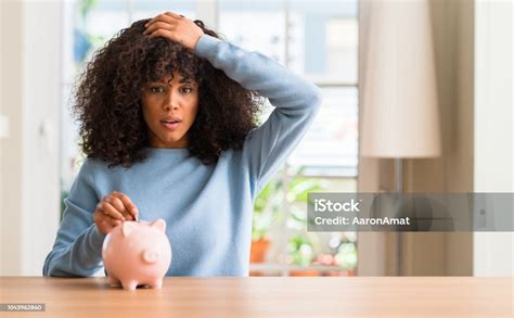 아프리카계 미국인 여자 저장 돈을 저금통에 스트레스 분노와 좌절 수치심과 깜짝 얼굴로 충격 을된 머리에 손을 두려워 하 고 실수에 대 한 화가 감정에 대한 스톡 사진 및