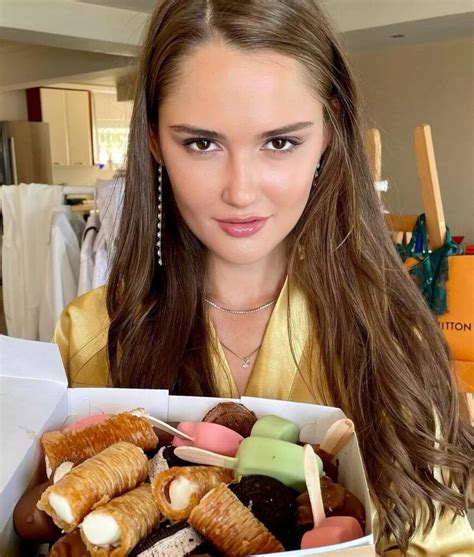 A Woman Holding A Box Full Of Assorted Pastries