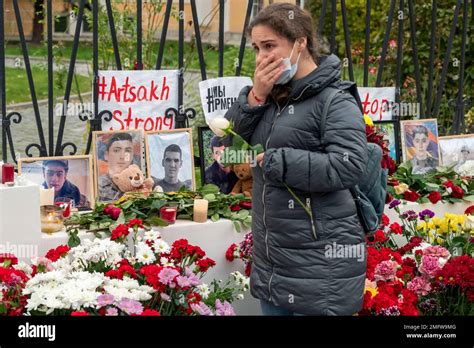 A Woman Reacts As She Lays A Flower At A Symbolic Memorial Of Victims