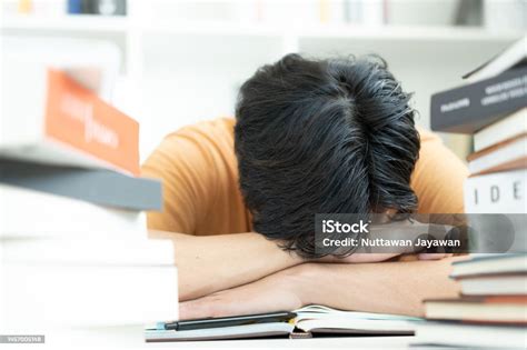 아시아 학생 남성은 시험 때문에 불안해하고 남성은 시험을 준비하고 도서관에서 수업을 듣습니다 스트레스 절망 서두름 오해 독서 낙담 기대 지식 피곤 25 29세에 대한 스톡