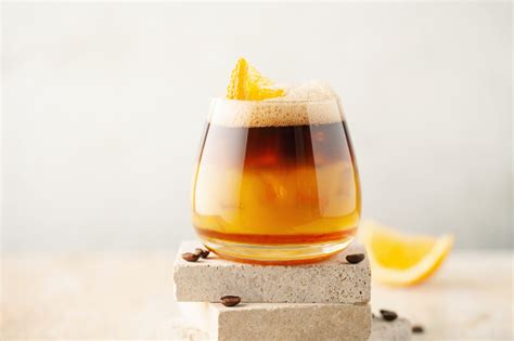 돌 배경에 얼음이 든 범블 커피 에스프레소 오렌지 주스 및 시럽을 얼음과 함께 투명한 유리에 겹겹이 겹겹이 겹겹이 쌓아 놓습니다