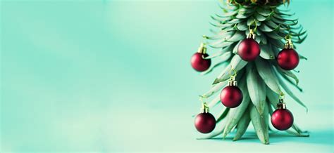 파인애플과 파란색 배경 복사 공간에 빨간색 값싼 물건으로 만든 창조적 인 크리스마스 트리 인사말 카드 새 해 파티를 위한 장식 휴일 개념입니다 배너 12월에 대한 스톡 사진