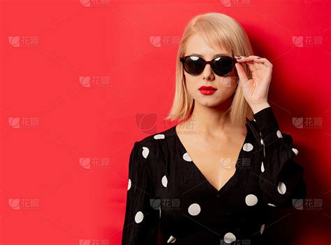 红色背景的漂亮女人戴着太阳镜