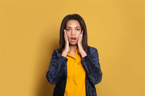 충격을 받은 흑인 여성 어두운 피부를 가진 놀란 아프리카 계 미국인 여성은 화려한 노란색 배경에 입을 엽니 다 감정에 대한 스톡