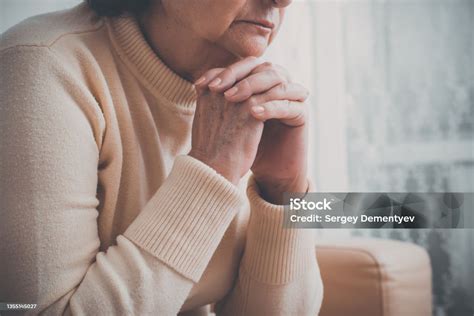 노인의 외로움 우울증 슬픈 분위기 정신 여성 건강 개념 접힌 주름진 손을 가진 노인을 가까이서 집에 혼자 앉아 있었다 외로운 선임 성숙한 여자 은퇴 60 69세에 대한 스톡