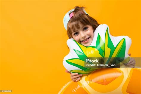오렌지 배경에 파인애플 고무 링이있는 수영복을 입은 야구 모자를 쓴 행복한 소녀 공기 주입에 대한 스톡 사진 및 기타 이미지 공기 주입 구조 노랑 Istock