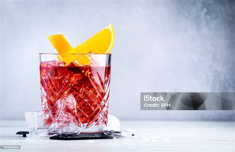 드라이 진 레드 베르무트 레드 비터 오렌지 슬라이스 아이스 큐브를 곁들인 네그로니 알코올 칵테일 음료 회색 배경 막대 도구 복사
