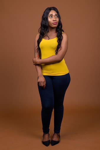 색 배경 노란색 민소매 탑을 입고 젊은 아름 다운 아프리카 여자의 스튜디오 샷 20 29세에 대한 스톡 사진 및 기타 이미지 20 29세 25 29세 갈색 배경