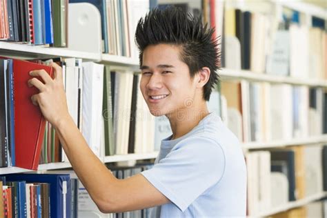 Studente Universitario Che Seleziona Libro A Partire Dalla Libreria Lei