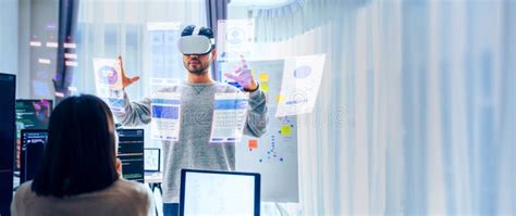 Asian Software Developer Wearing A Virtual Reality Headset Works On A