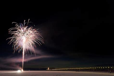 Premium Photo Firework Exploding Over Landscape Against Sky At Night