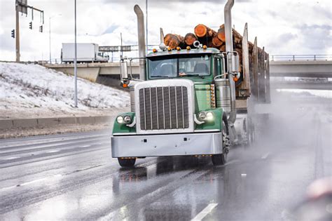 녹는 눈과 물 먼지와 넓은 겨울 젖은 도로에서 실행 세미 트레일러에 로그를 수송 녹색 클래식 큰 장비 세미 트럭 비에 대한 스톡 사진 및 기타 이미지 Istock
