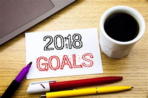 2018 목표를 보여주는 필기 텍스트 캡션 재무 기획 사업 전략 노트북 커피와 함께 사무실에서 나무 바탕에 노트북도 서에 대 한 쓰기 비즈니스 개념 2018년에 대한 스톡