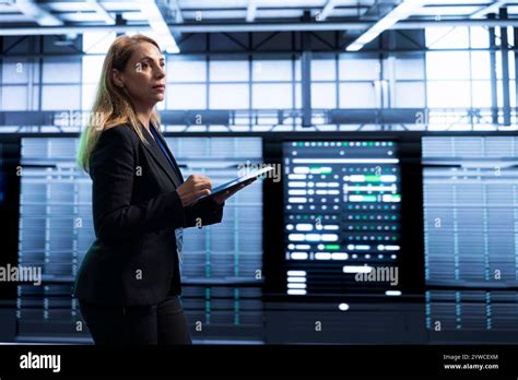 Manager In Server Room Using Tablet To Implement And Maintain Security