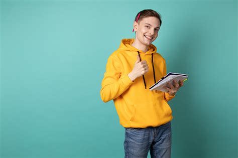 손에 노트북과 귀 뒤에 펜을 가진 노란 까마귀에 있는 젊은 잘생긴 디자이너 교육에 대한 스톡 사진 및 기타 이미지 교육 남자 대학교 Istock