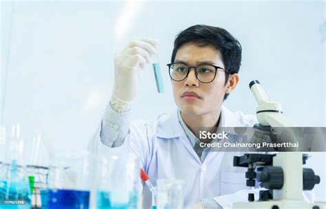 닫기 아시아 과학자 남자 책상에 앉아 의료 의료 및 제약 개념에 대 한 연구 및 개발을 위한 실험실 에서 과학적인 액체 솔루션 형태 비커를 혼합 후 테스트 튜브 플라 스크를