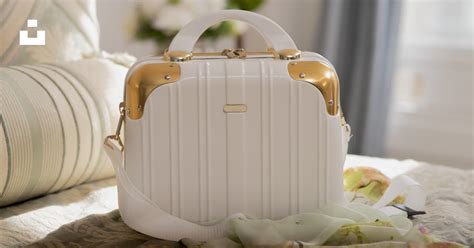 침대 위에 앉아있는 흰색 여행 가방 사진 Unsplash의 무료 창의적인 제품 샷 이미지