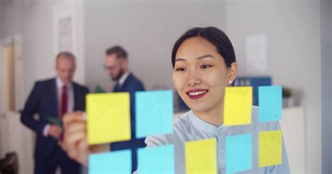 아시아 여성 직원이 사무실에서 비즈니스 프로젝트를 개발하는 다채로운 스티커 메모에 글을 씁니다 가리키기에 대한 스톡 사진 및 기타 이미지 Istock