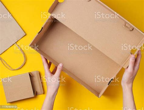 여성의 손은 종이 가방과 상자와 노란색 배경에 빈 골판지 상자를 들고 맨 위 보기 가리기에 대한 스톡 사진 및 기타 이미지 가리기 가방 공란 Istock