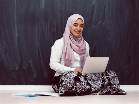 Arab Teenager With Hijab Sitting On The Floor Of The House And Watching
