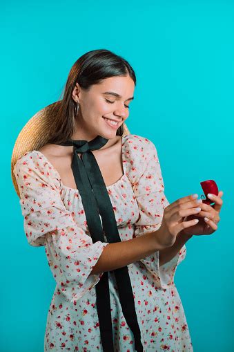 매력적인 젊은 여성은 파란색 벽 배경에 제안 다이아몬드 반지와 작은 보석 상자를 들고 여자 미소 그녀는 선물을 얻을 행복 결혼에 대한 제안 남자에 대한 스톡 사진 및 기타