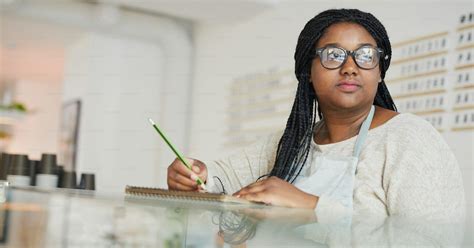 젊은 혼혈 여성이 페이스트리를 들고 진열되어 메모장에 작업 노트를 만들고 있다 사진 Unsplash의 러시아 이미지