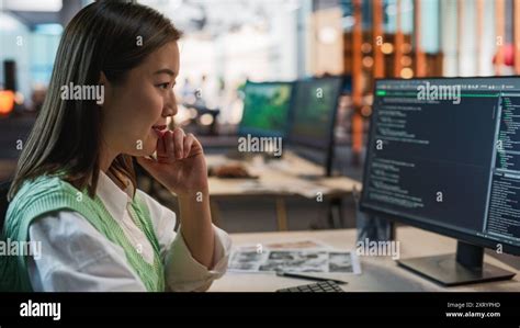 Female Asian Game Programmer Coding On Desktop Computer In Game