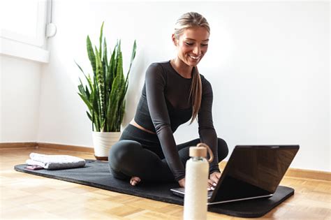 여자 휴식 및 노트북은 온라인 자습서 스트리밍 비디오 및 선 지침의 집에서 요가를 위해 사용합니다 여성 웰빙 앱 필라테스 구독 및 마음 챙김을위한 기술 및 피트니스 웹