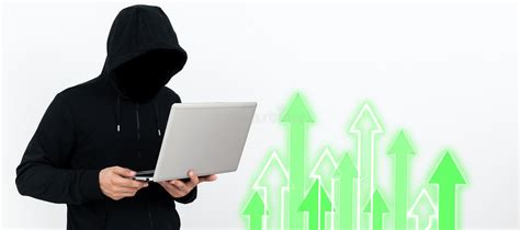 Male Programmer In Black Hoodie Stands And Holds Laptop Hacker With Hood On His Head Typing