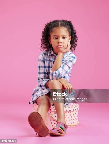 스튜디오에 앉아서 분홍색 카피 스페이스 배경에 백일몽을 꾸는 귀여운 작은 혼합 경주 소녀 슬프고 우울해 보이는 외로운 아프리카계